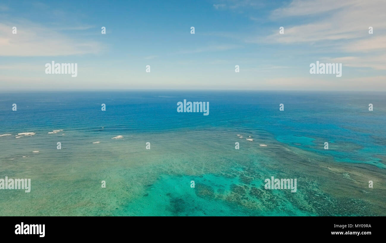 Flying over the blue sea in the azure lagoon. Aerial view: water ...