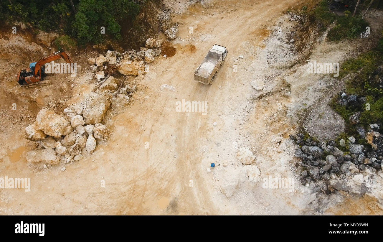 Excavator loads the truck in a limestone quarry. Aerial view wheel ...