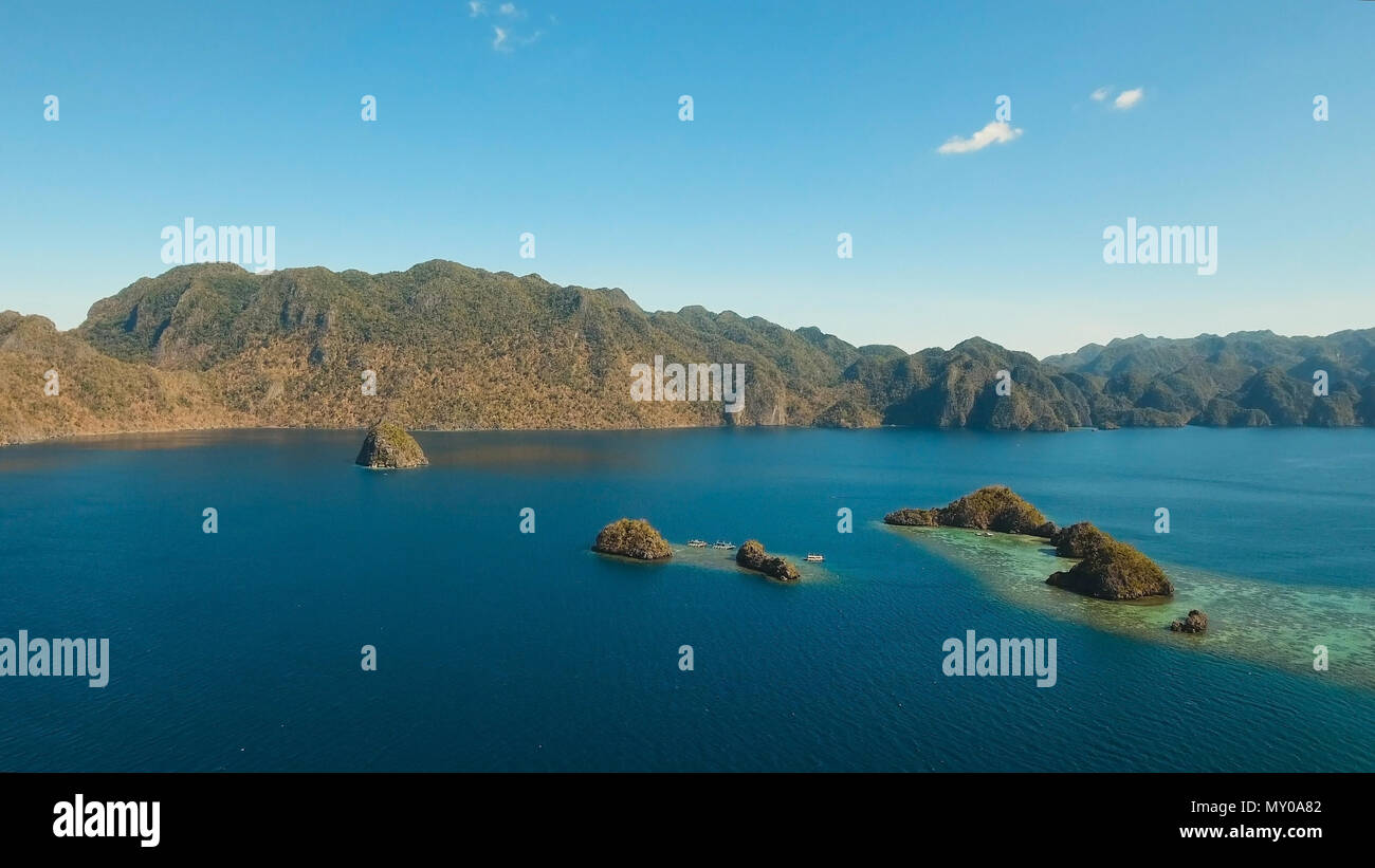 Aerial view: beach, tropical island, sea bay and lagoon, mountains with ...
