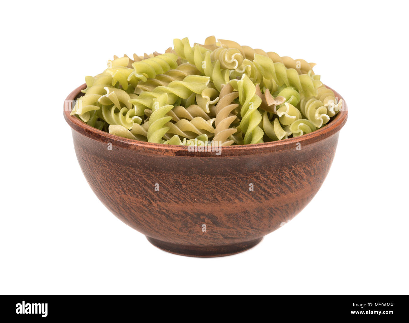Green pasta fusilli in a bowl on white background Stock Photo - Alamy