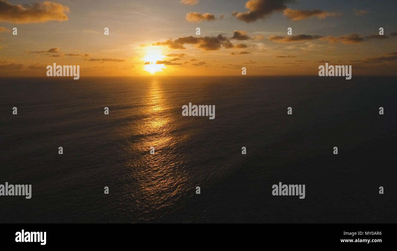 Aerial view orange sunset over the sea, the ocean. Flying over the blue ...