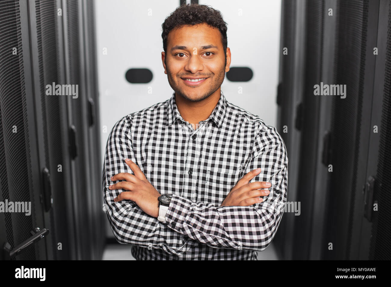 Cheerful IT guy visiting server room Stock Photo - Alamy