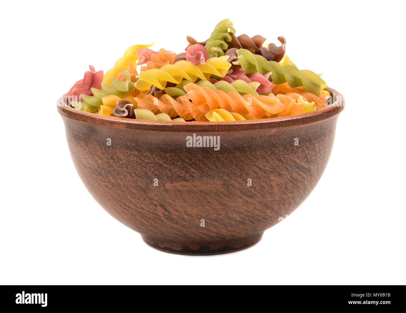 Raw colored pasta fusilli in a bowl on white background Stock Photo - Alamy