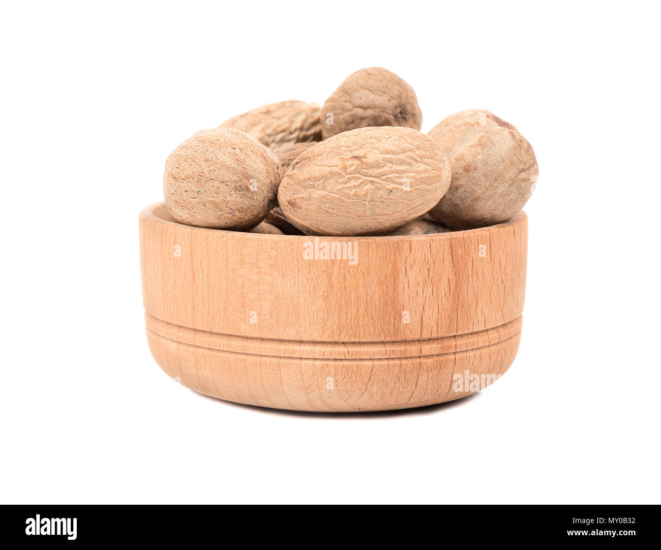 Dry nutmeg in a wooden bowl isolated on white background Stock Photo ...