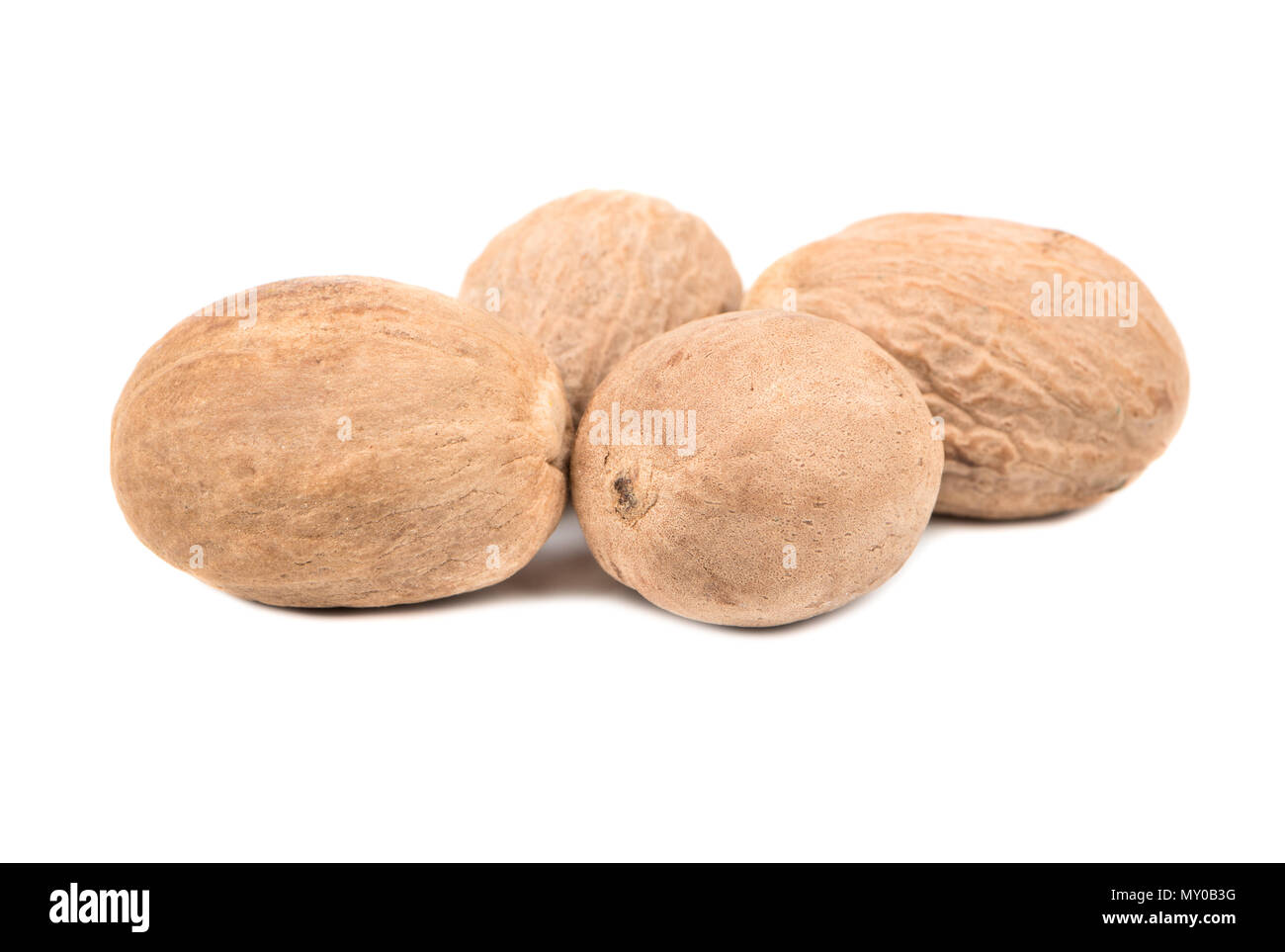 Some dry nutmeg on a white background closeup Stock Photo - Alamy