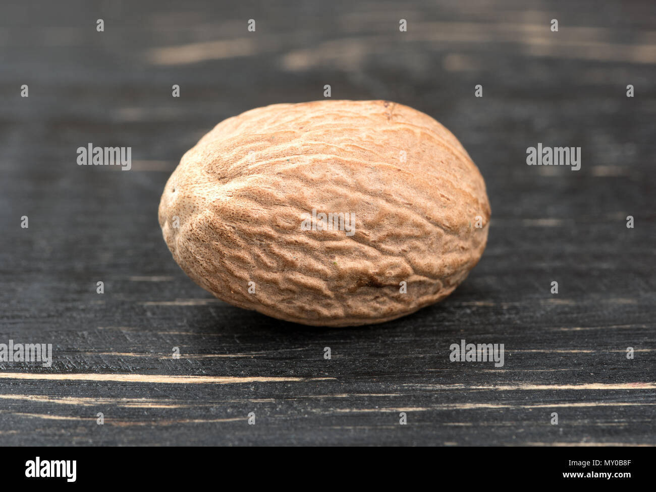 Dry nutmeg on dark table close up Stock Photo - Alamy