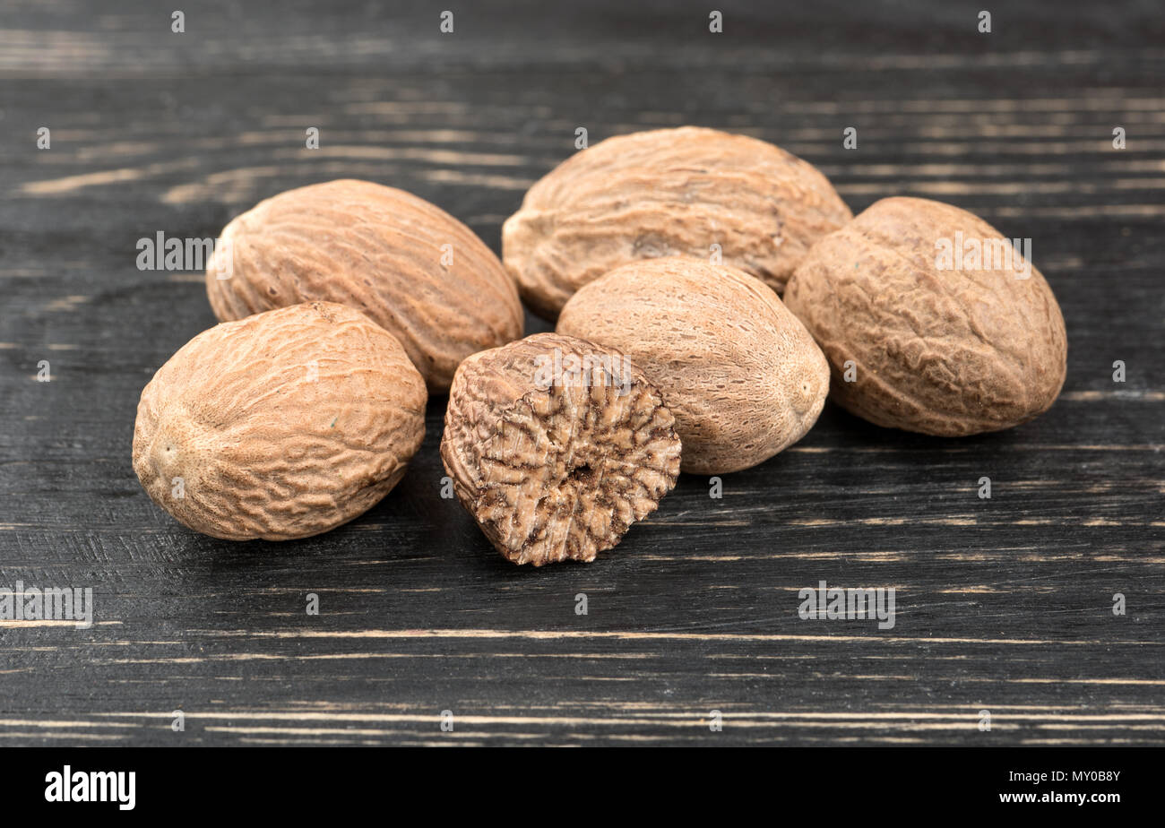 Some dry nutmeg on dark wooden background Stock Photo - Alamy
