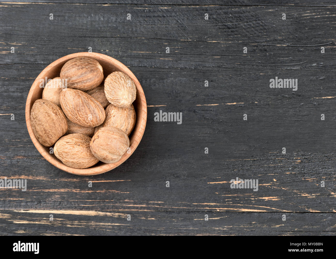 Dry nutmeg in the bowl on empty wooden background Stock Photo - Alamy