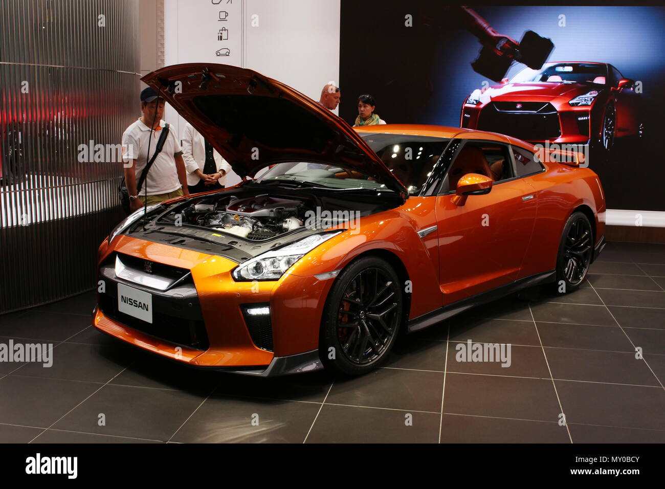 Visitors view a Nissan GT-R on display at the Nissan Crossing showroom ...