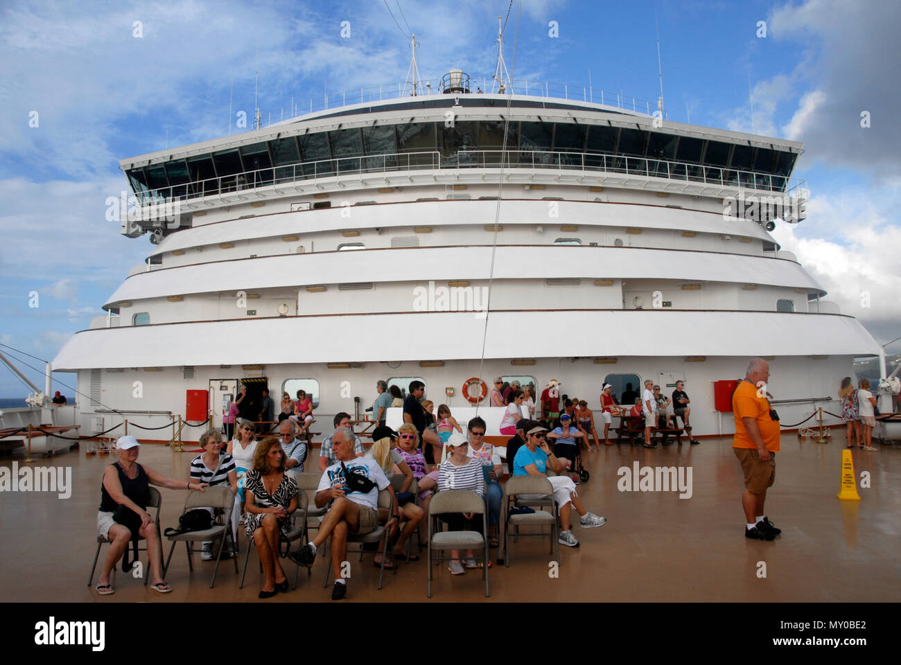 Passengers on the fore deck of a cruise liner enjoying the sunshine and ...