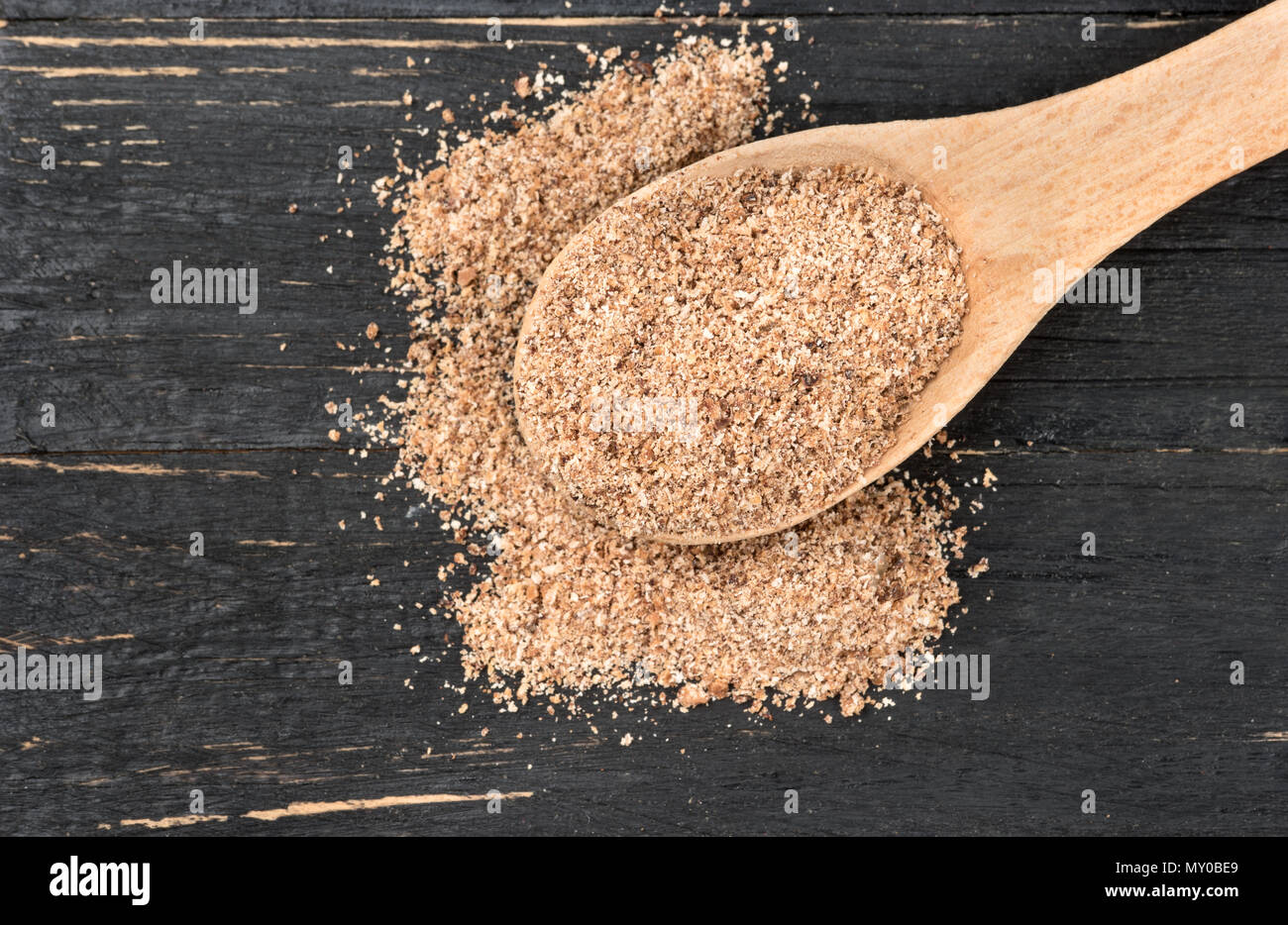Nutmeg powder in spoon on wooden background, top view Stock Photo - Alamy
