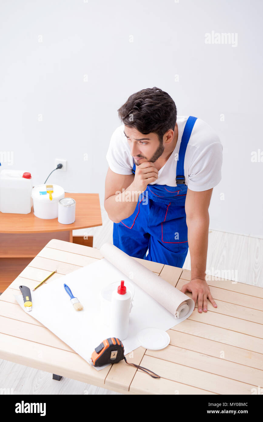 Worker working on wallpaper during refurbishment Stock Photo - Alamy