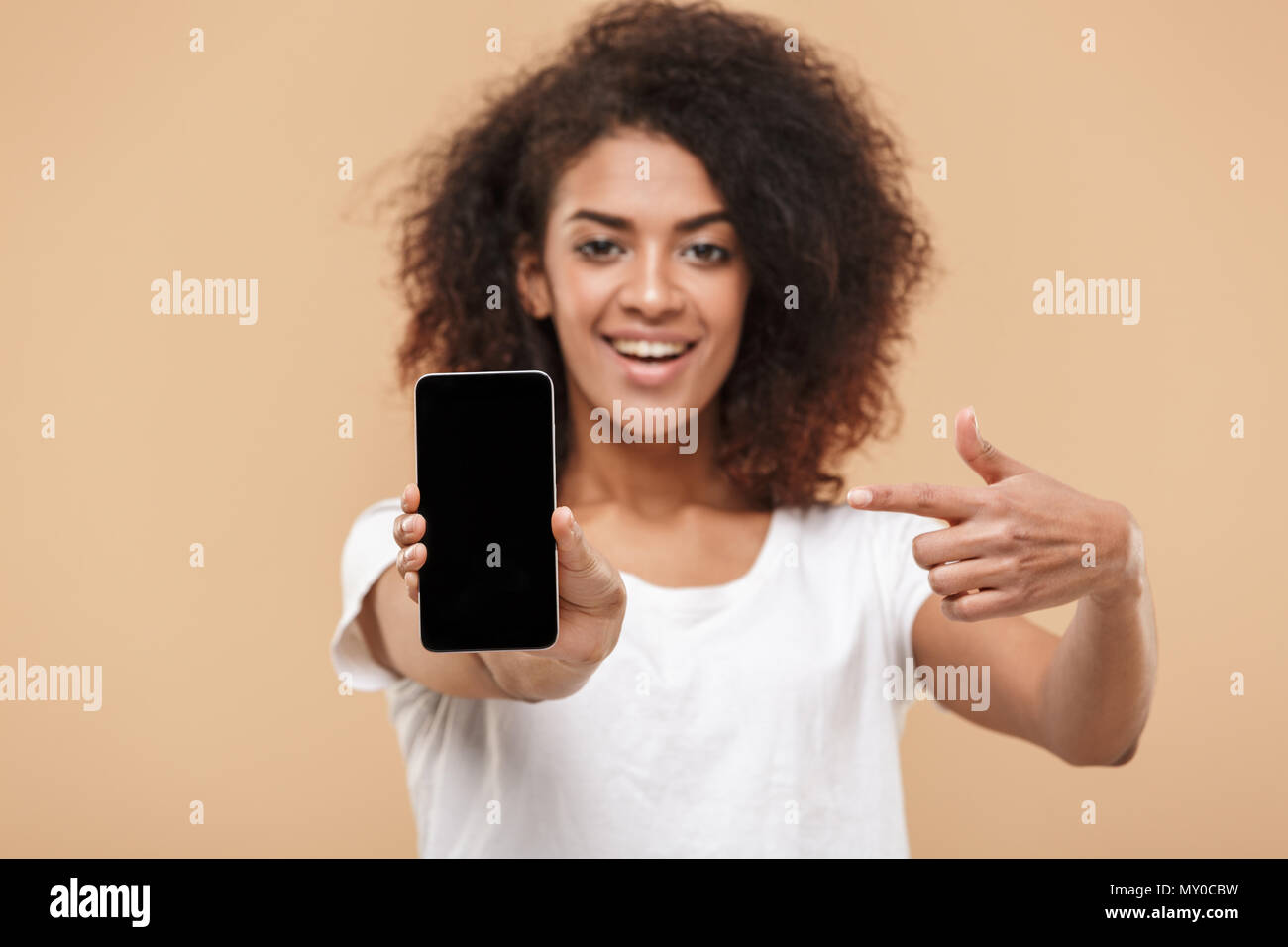 Portrait of a smiling young african woman poinitng finger at blank ...