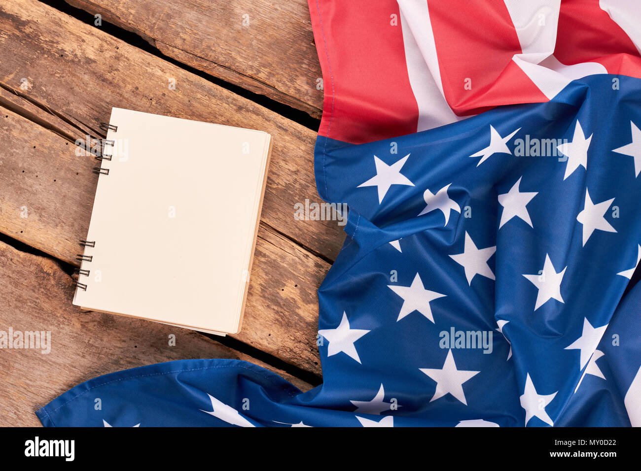 Crumpled American flag and notebook. Ruffled USA satin flag and blank ...