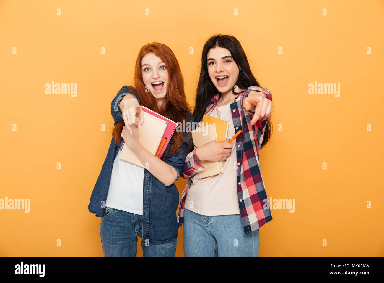 Portrait of two happy young school teenage girls holding copybooks and ...