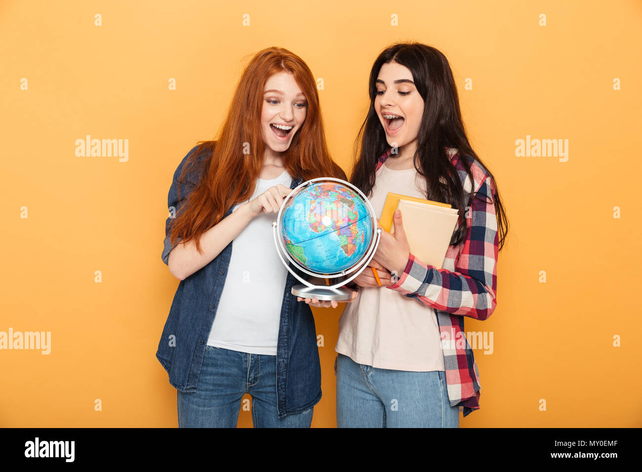 Portrait of two happy young school teenage girls holding copybooks and ...