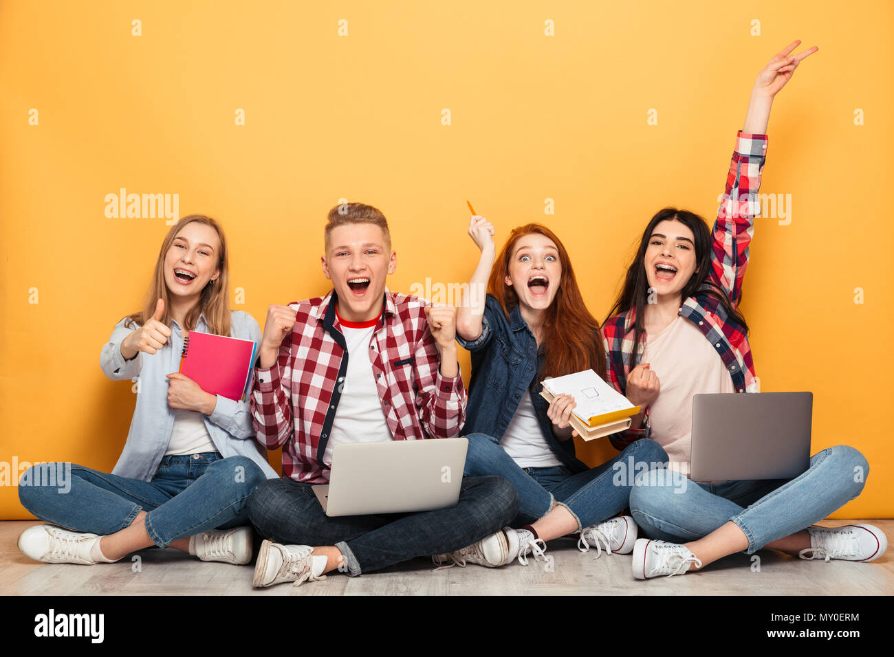 Group of happy school friends doing homework while sitting together on ...