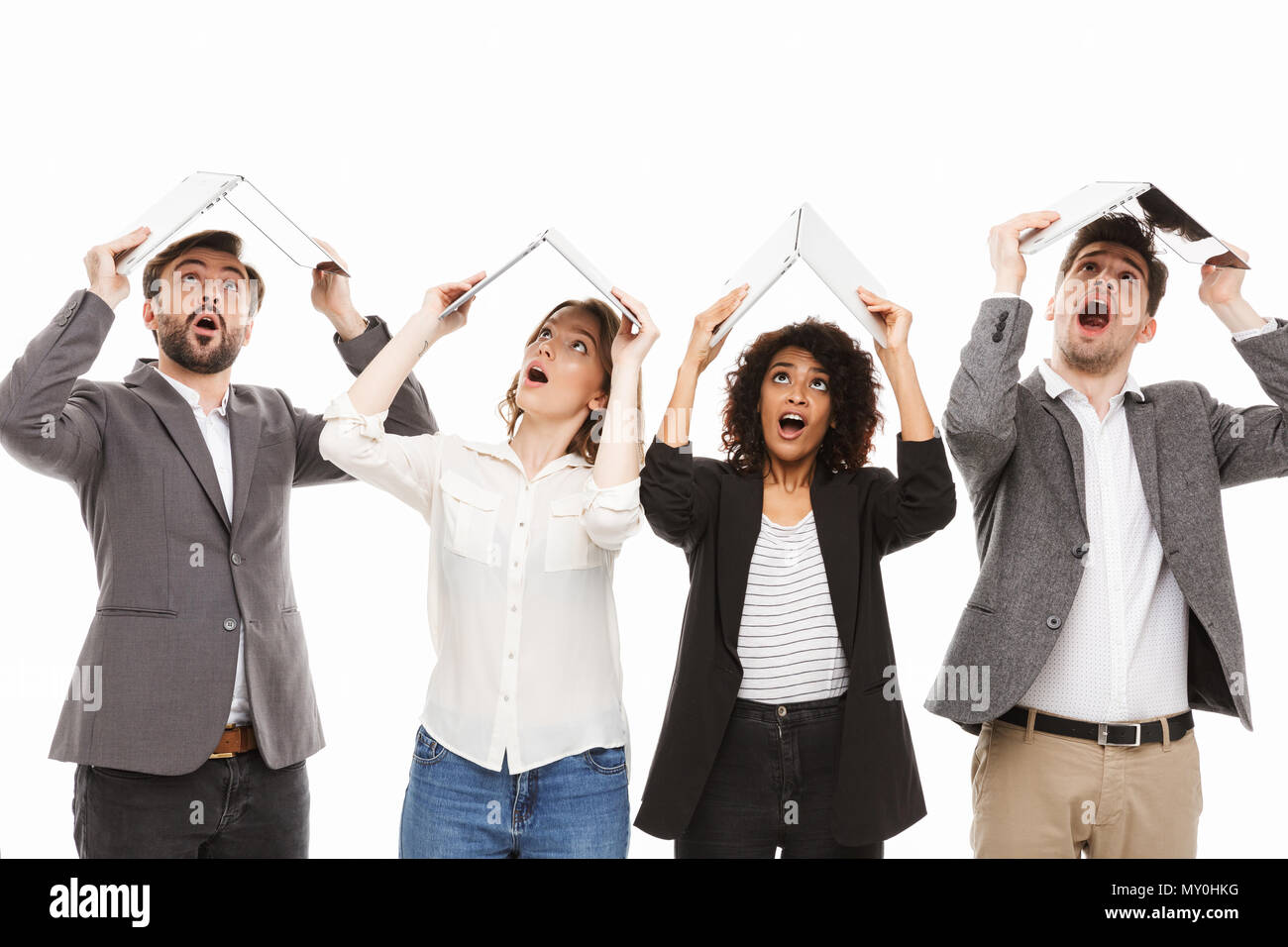 Portrait of a group of shocked multiracial business people holding ...