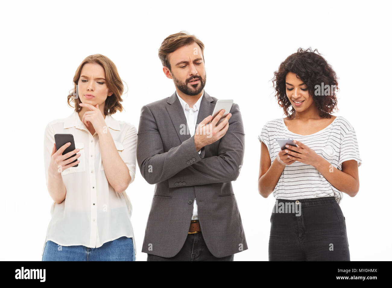 Group of pensive young multiethnic business people using mobile phones ...