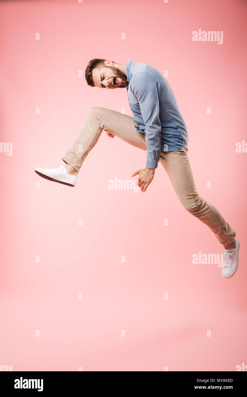 Full length of a happy young man jumping and celebrating success ...