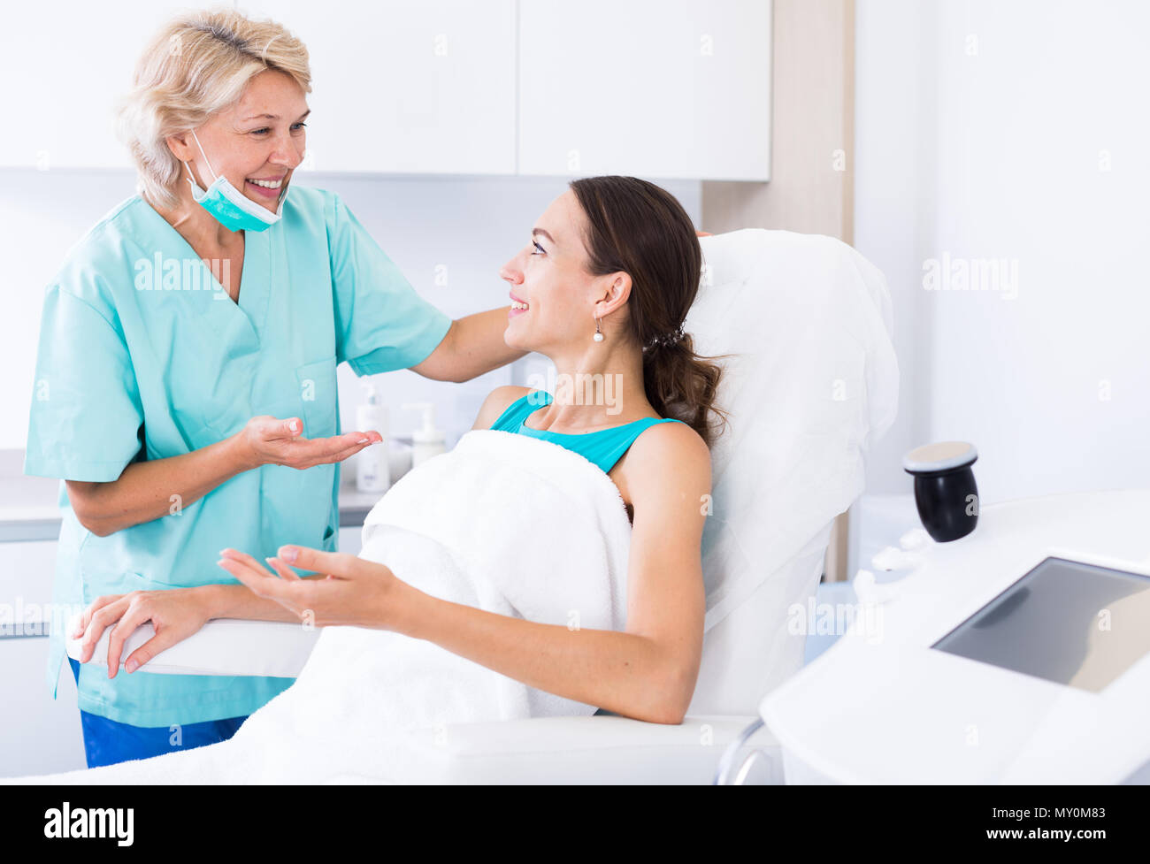 Skillful cosmetologist consulting lady in medical esthetic office Stock ...