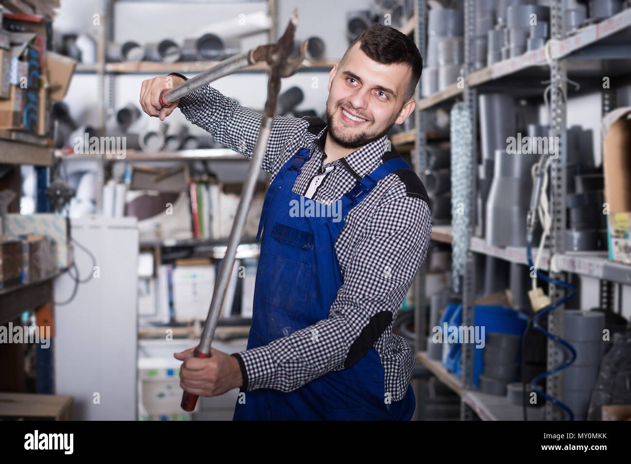 Positive builder male showing various tools at workshop Stock Photo - Alamy