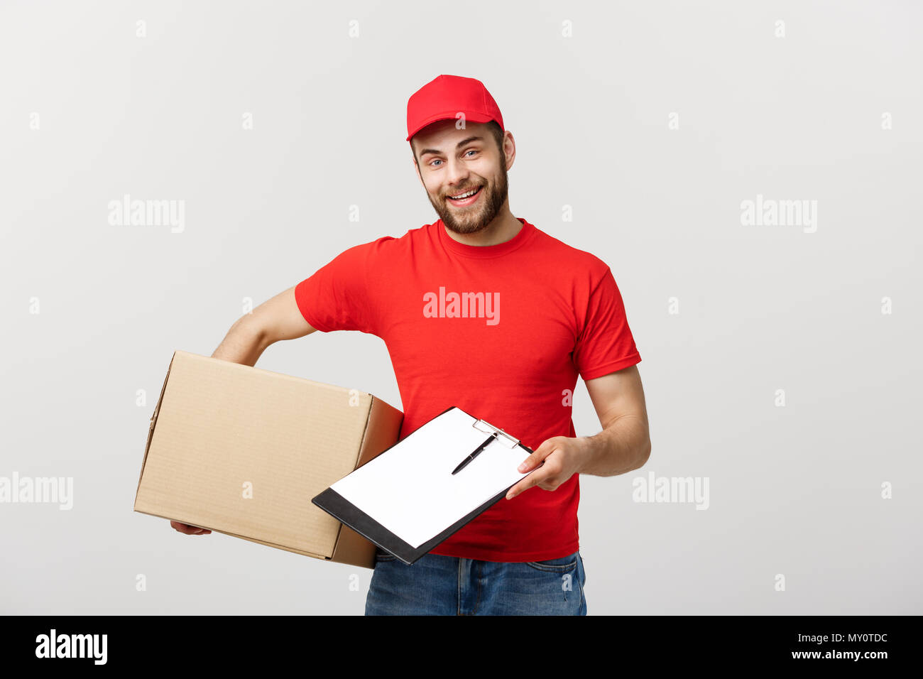 Delivery Concept: Young handsome delivery man with paper boxes giving ...