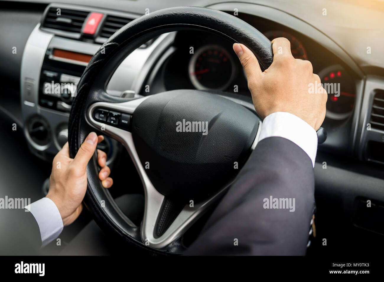 Portrait of a young handsome businessman driving a luxury sports car ...
