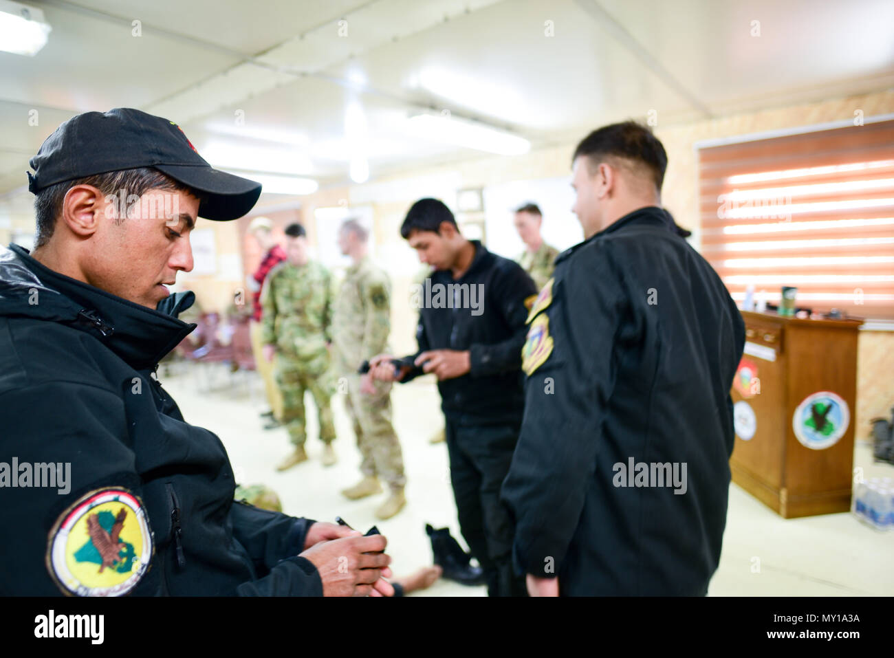 An Iraqi Counter-Terrorism Service soldier prepares a tourniquet for ...