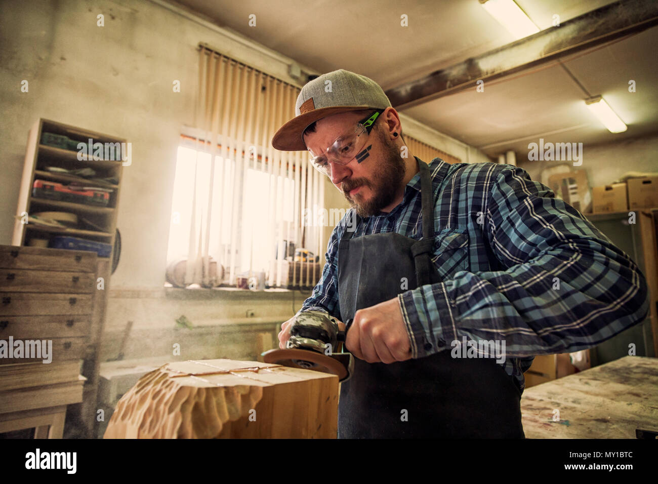 Experienced carpenter in work clothes and small buiness owner working ...