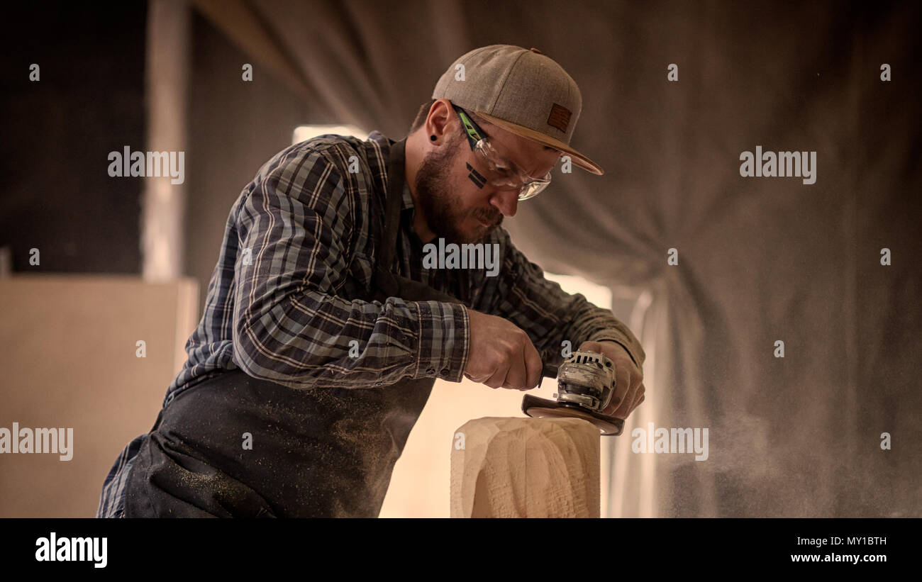 Experienced carpenter in work clothes and small buiness owner working ...