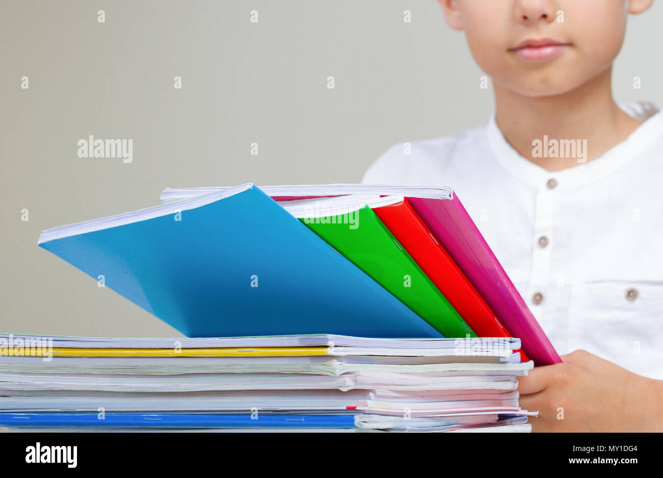 Kid with colorful books, notebooks and textbooks doing homework Stock ...