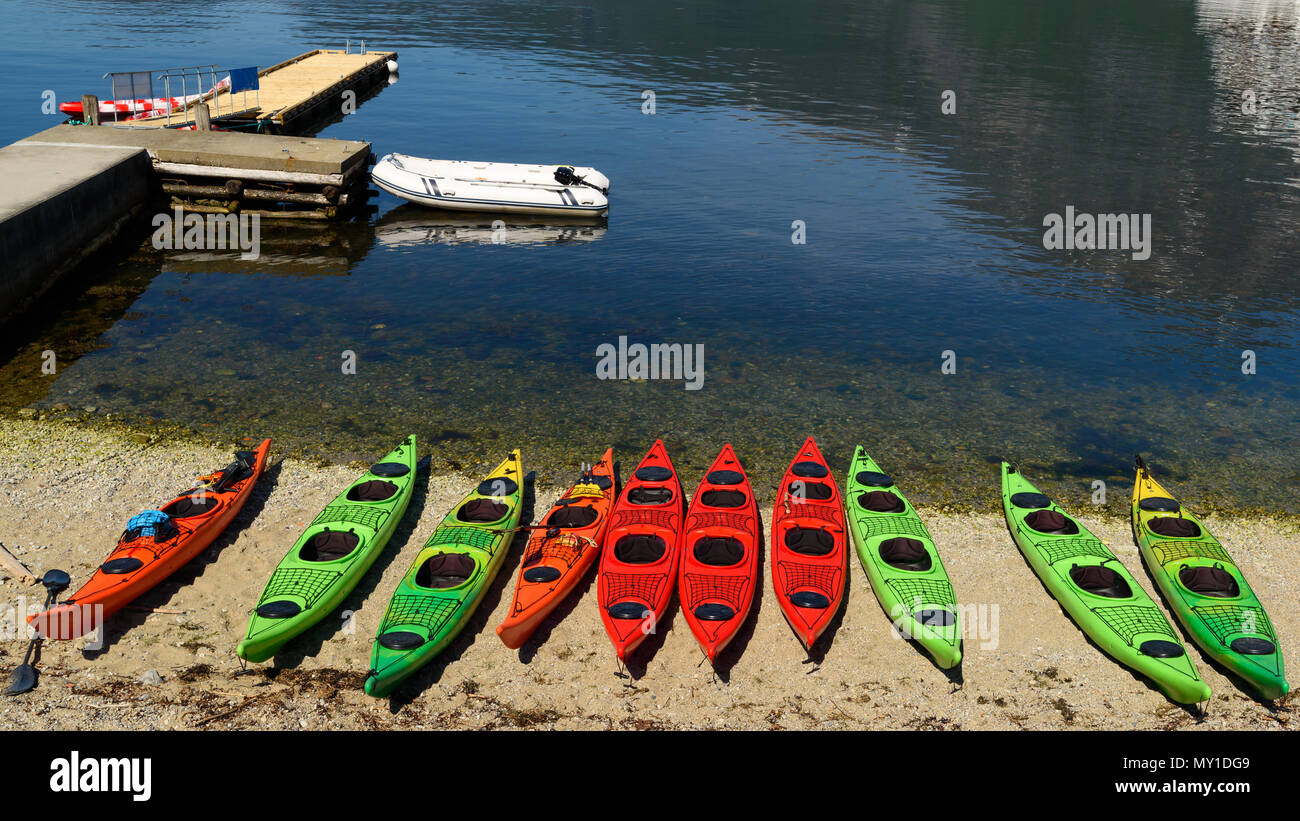 Colorful canoes along the beach with windless sea and a rubber boat in ...