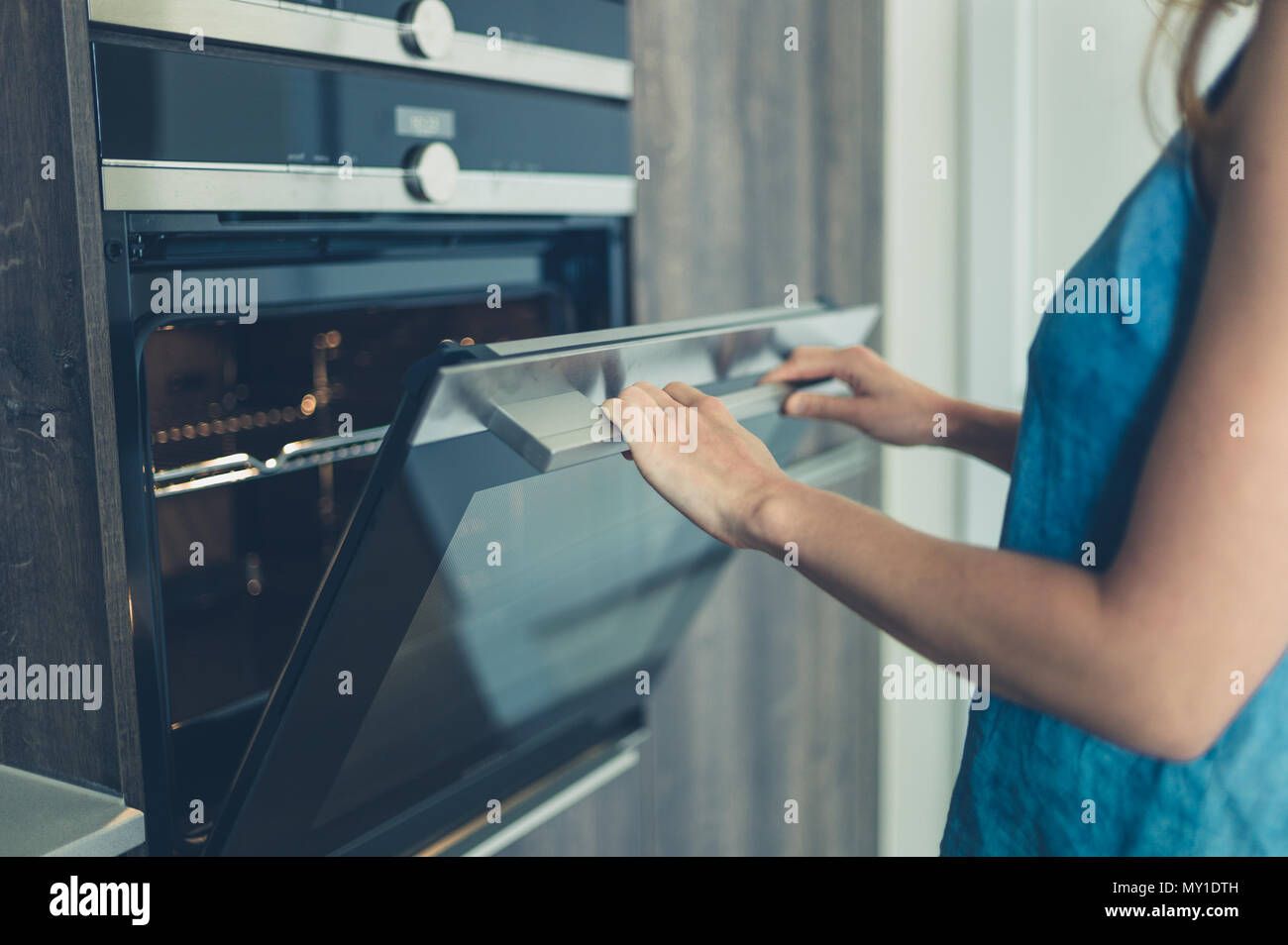 Woman opening oven hi-res stock photography and images - Alamy