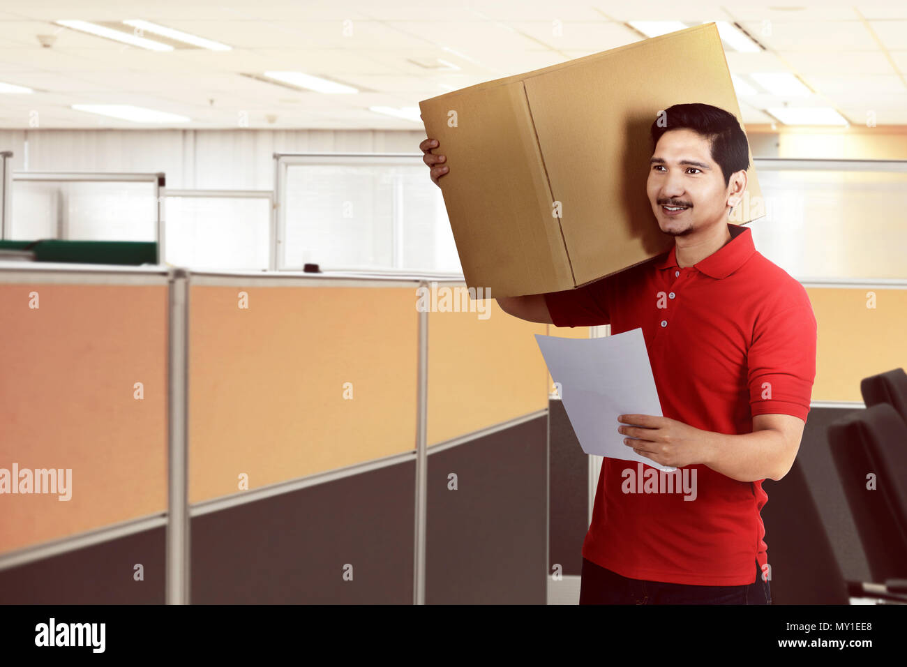 Handsome asian delivery man holding the package and sending to office ...