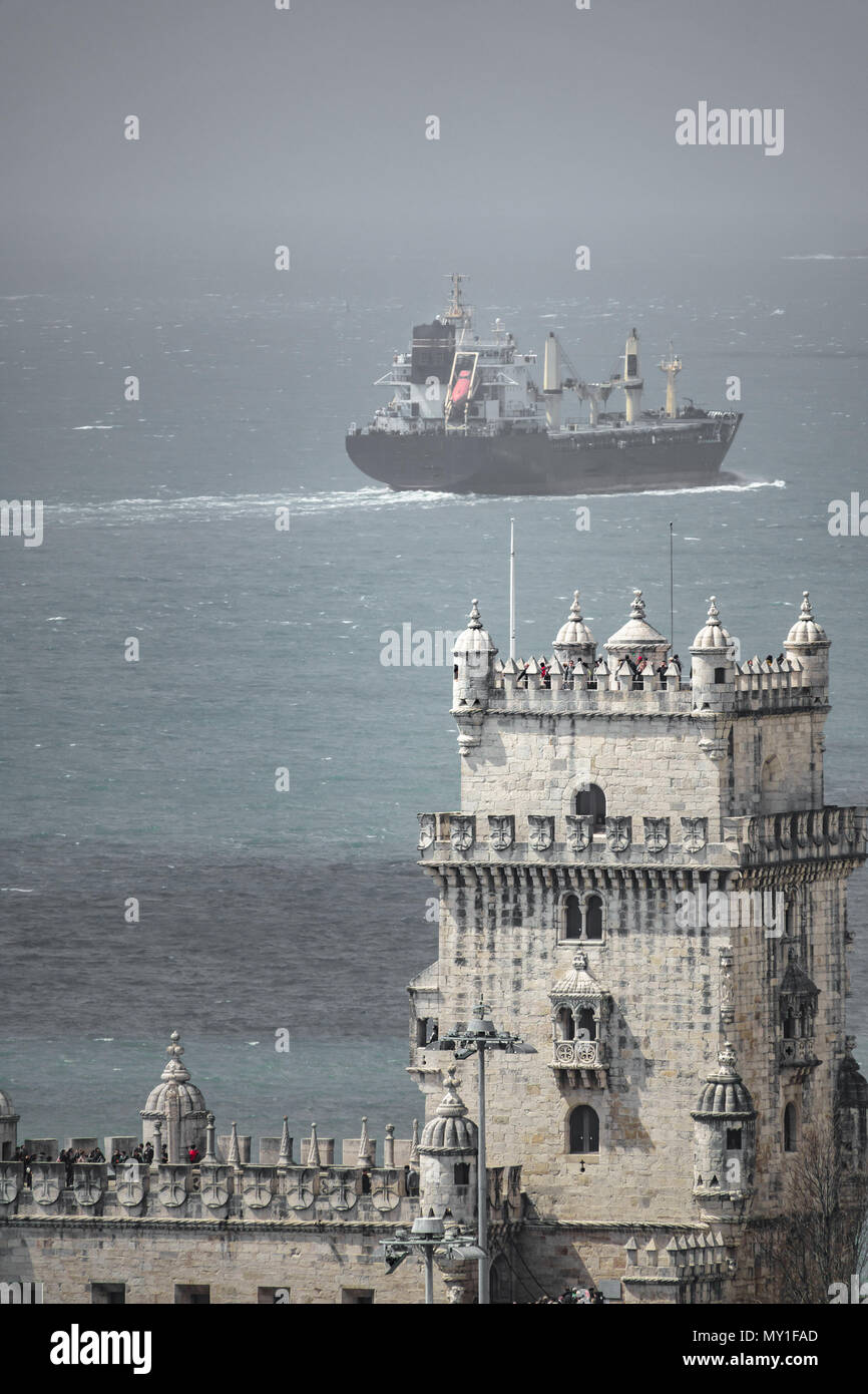 Belem tower with large cargo ship Stock Photo - Alamy
