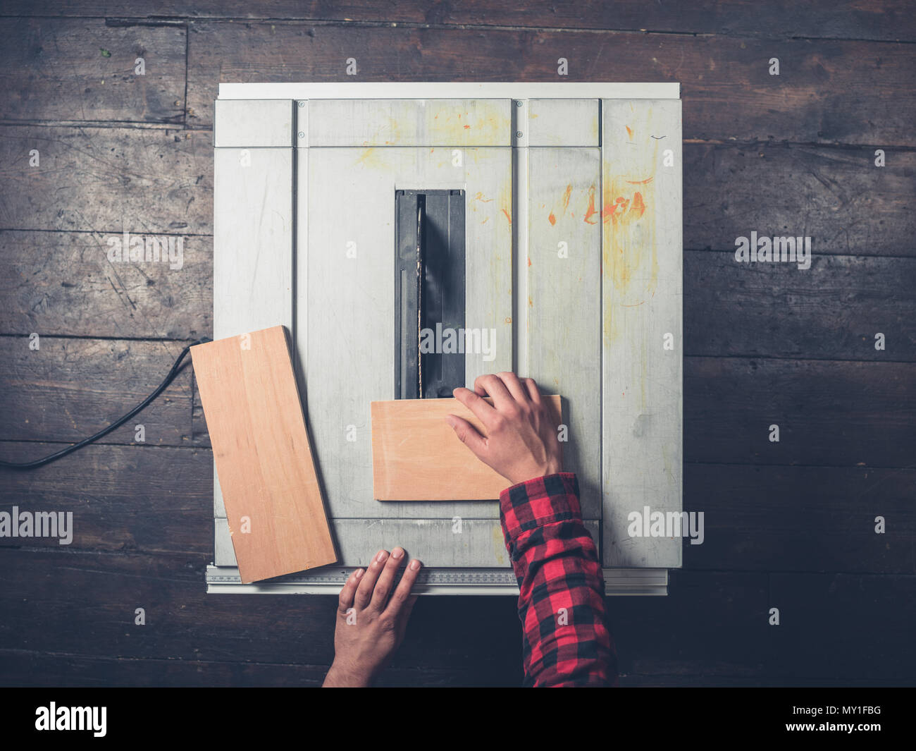 A young man's arm and hand operating a tablesaw Stock Photo - Alamy