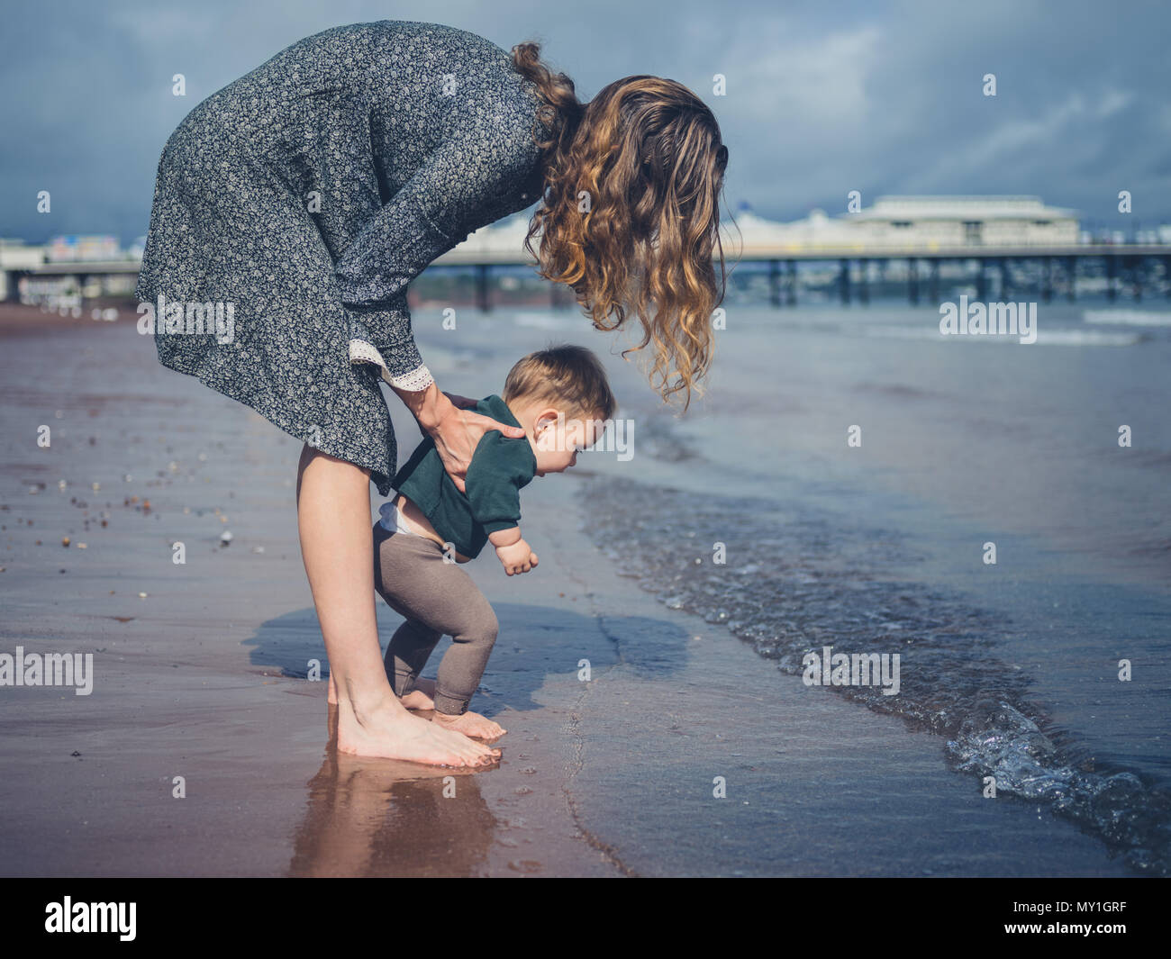 Mother helping baby to walk hi-res stock photography and images - Alamy