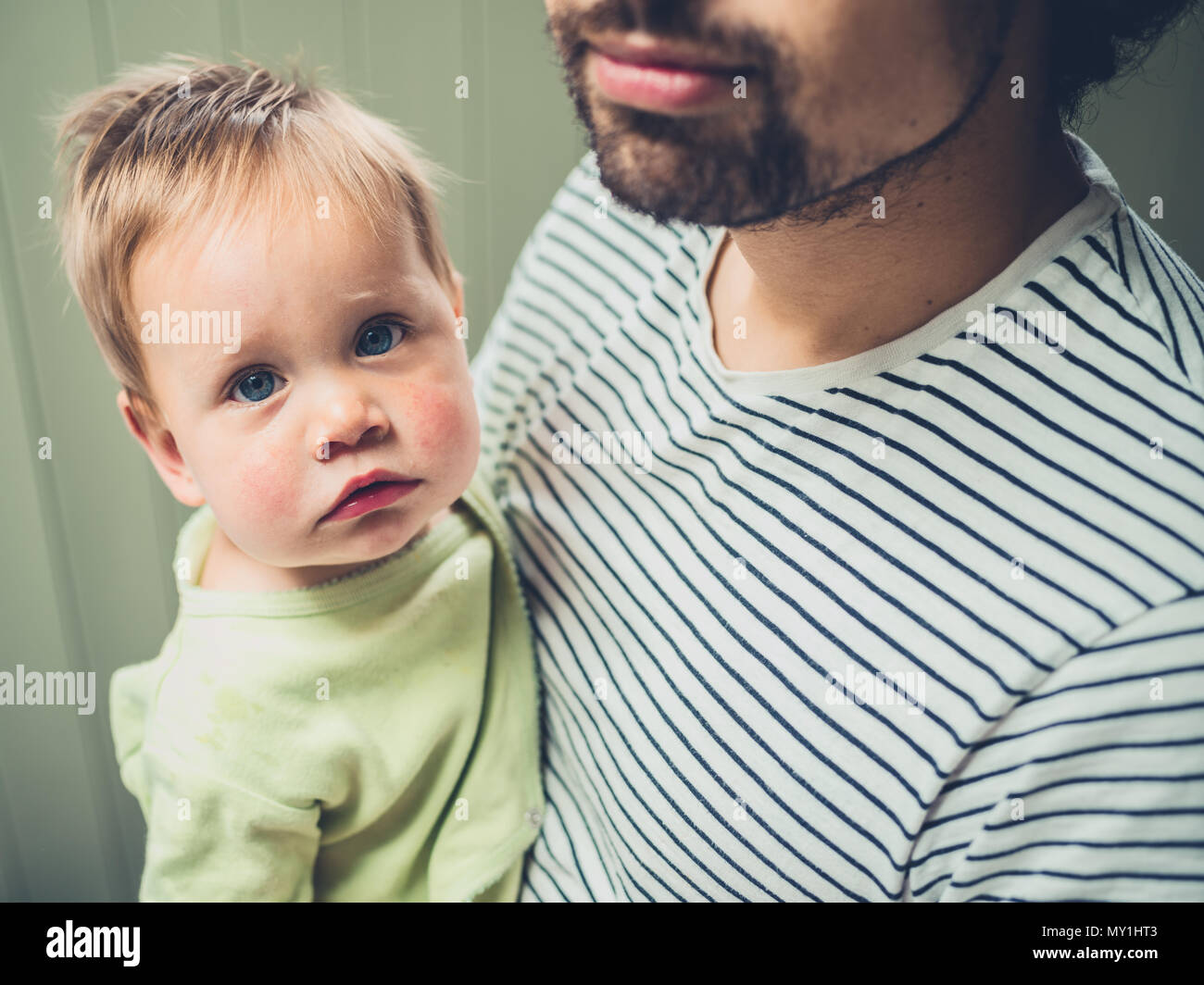 A young father is holding his baby son Stock Photo - Alamy