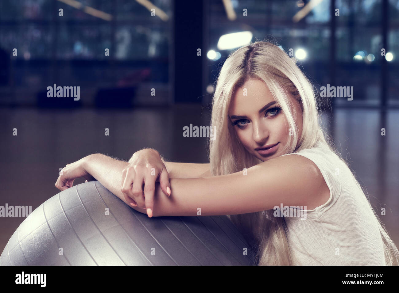 Beautiful blonde woman with gray exercise ball Stock Photo - Alamy