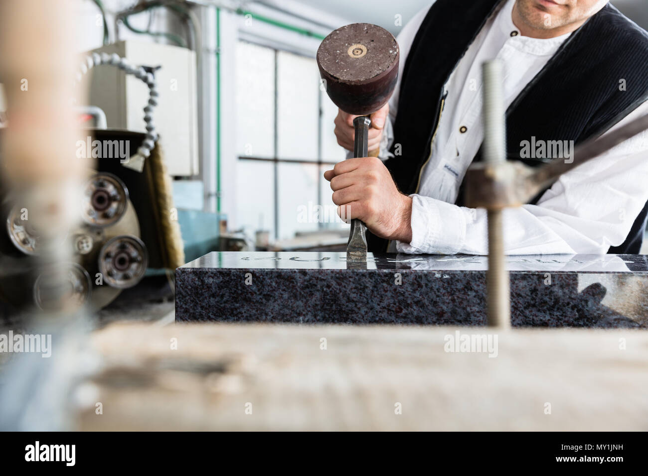 Stone mason working on tombstone in workshop Stock Photo - Alamy