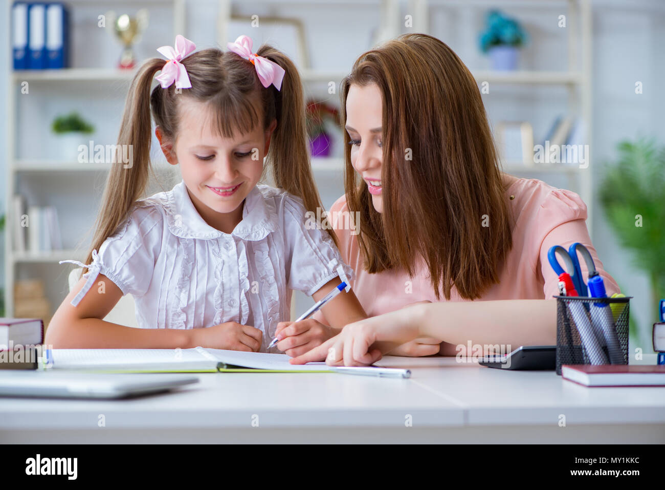 Mother helping her daughter to do homework Stock Photo - Alamy