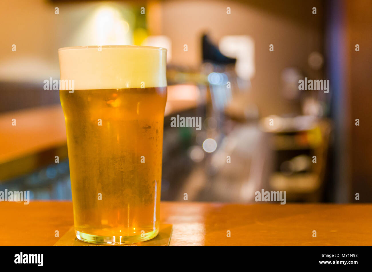 Glass pint of beer on top of bar counter, brewpub, craftbeer Stock ...