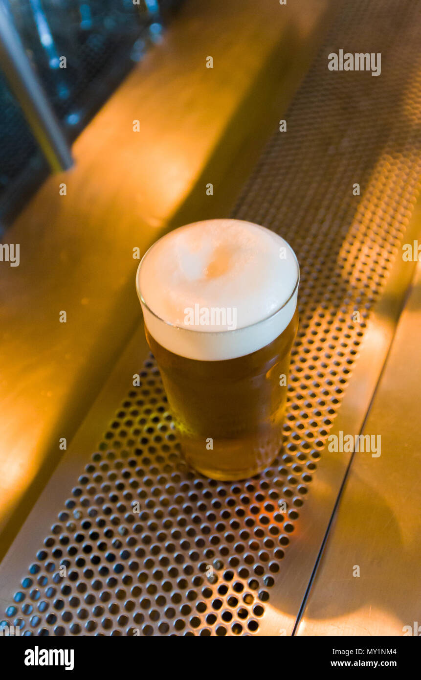 Glass pint of beer on top of bar counter, brewpub, craftbeer Stock ...