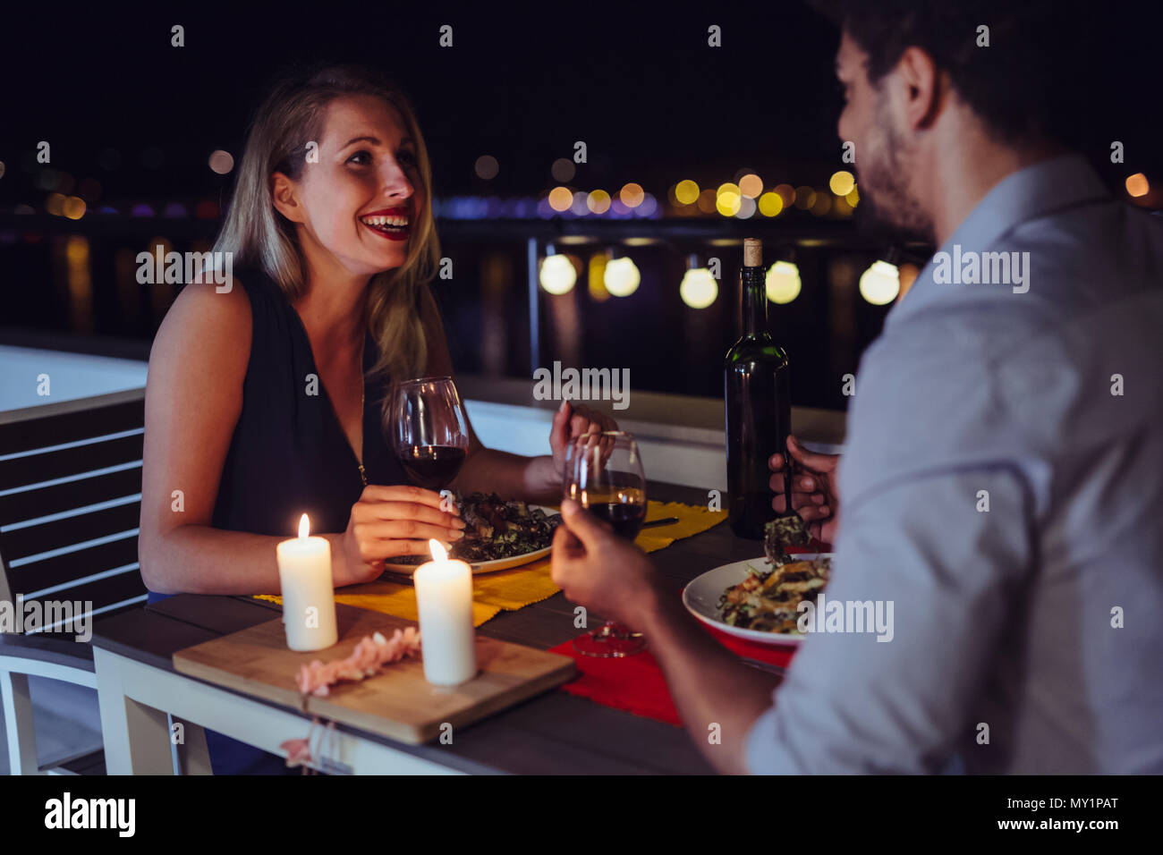 Young beautiful couple having romantic dinner on rooftop Stock Photo ...