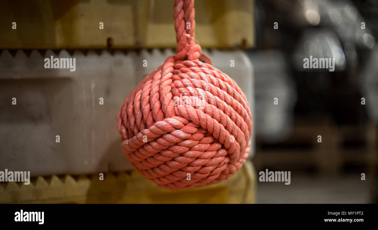 Beautiful hanging ball coral color of thread on a fabric background ...