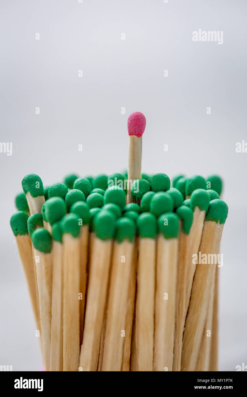 a lot of green matches and one red, leadership, light background, fire ...