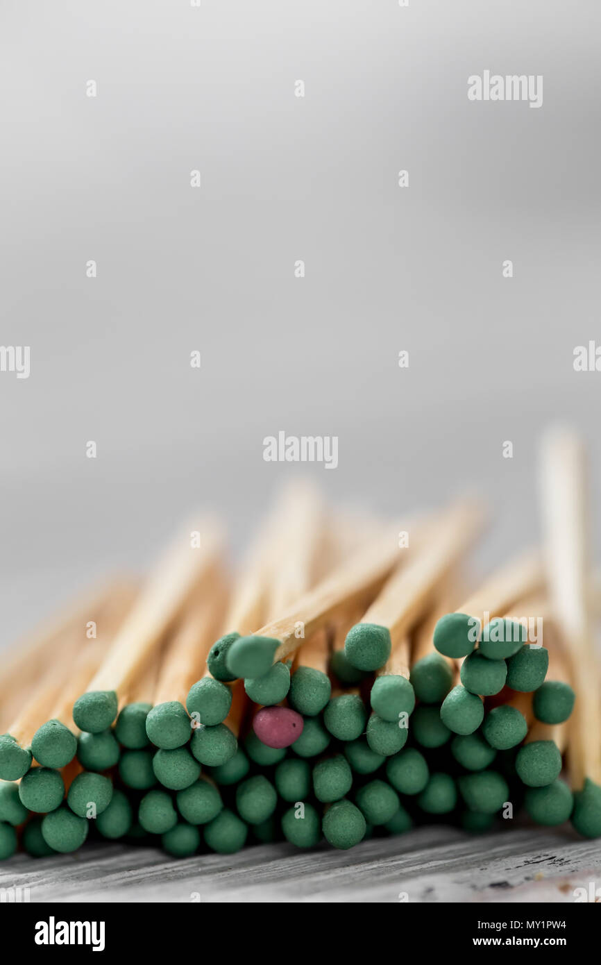 a lot of green matches and one red, leadership, light background, fire ...