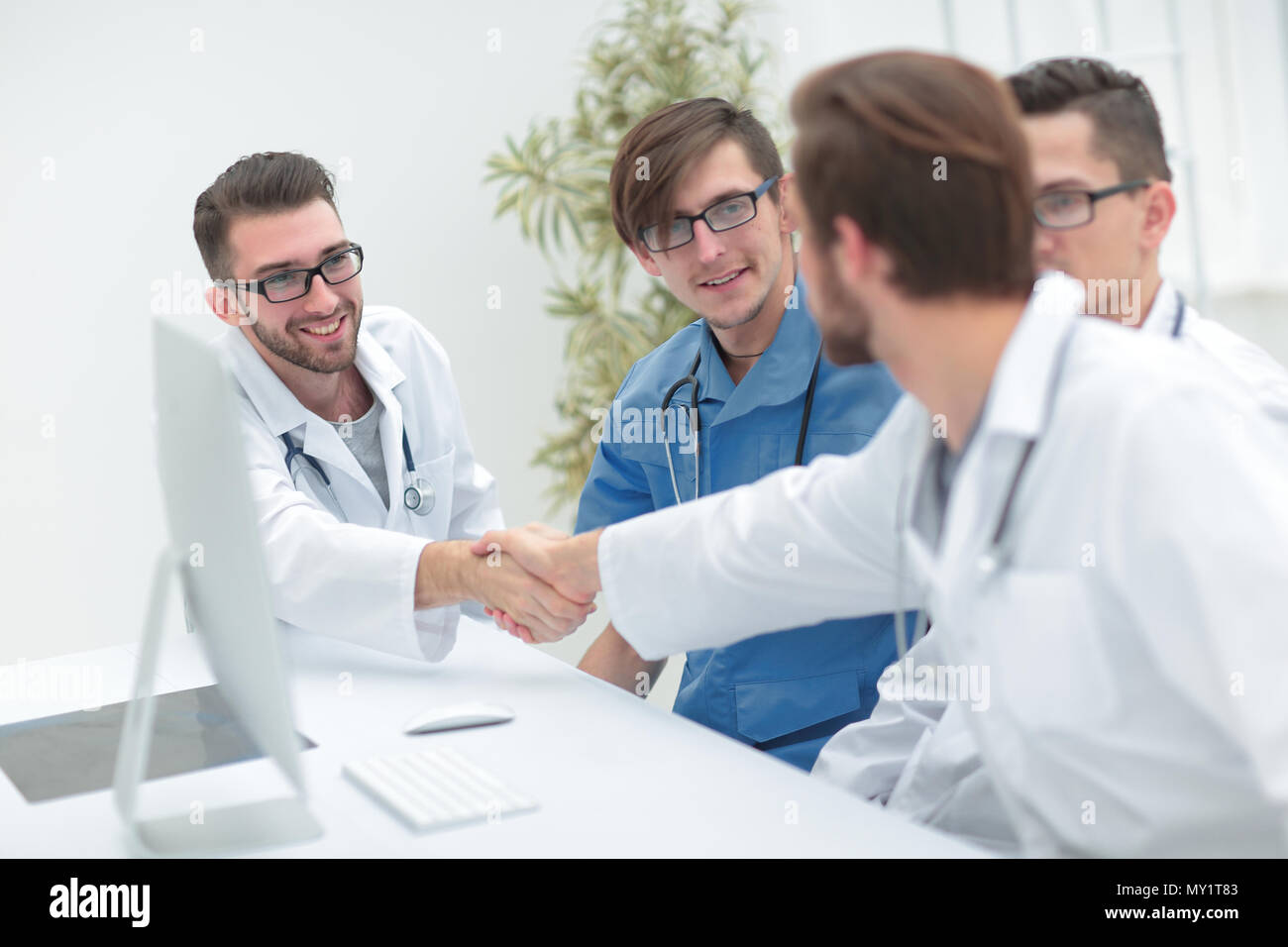 Friendly handshake between colleagues hi-res stock photography and ...