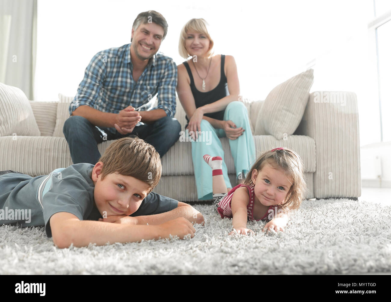 Portrait of happy family sitting together in living room Stock Photo ...